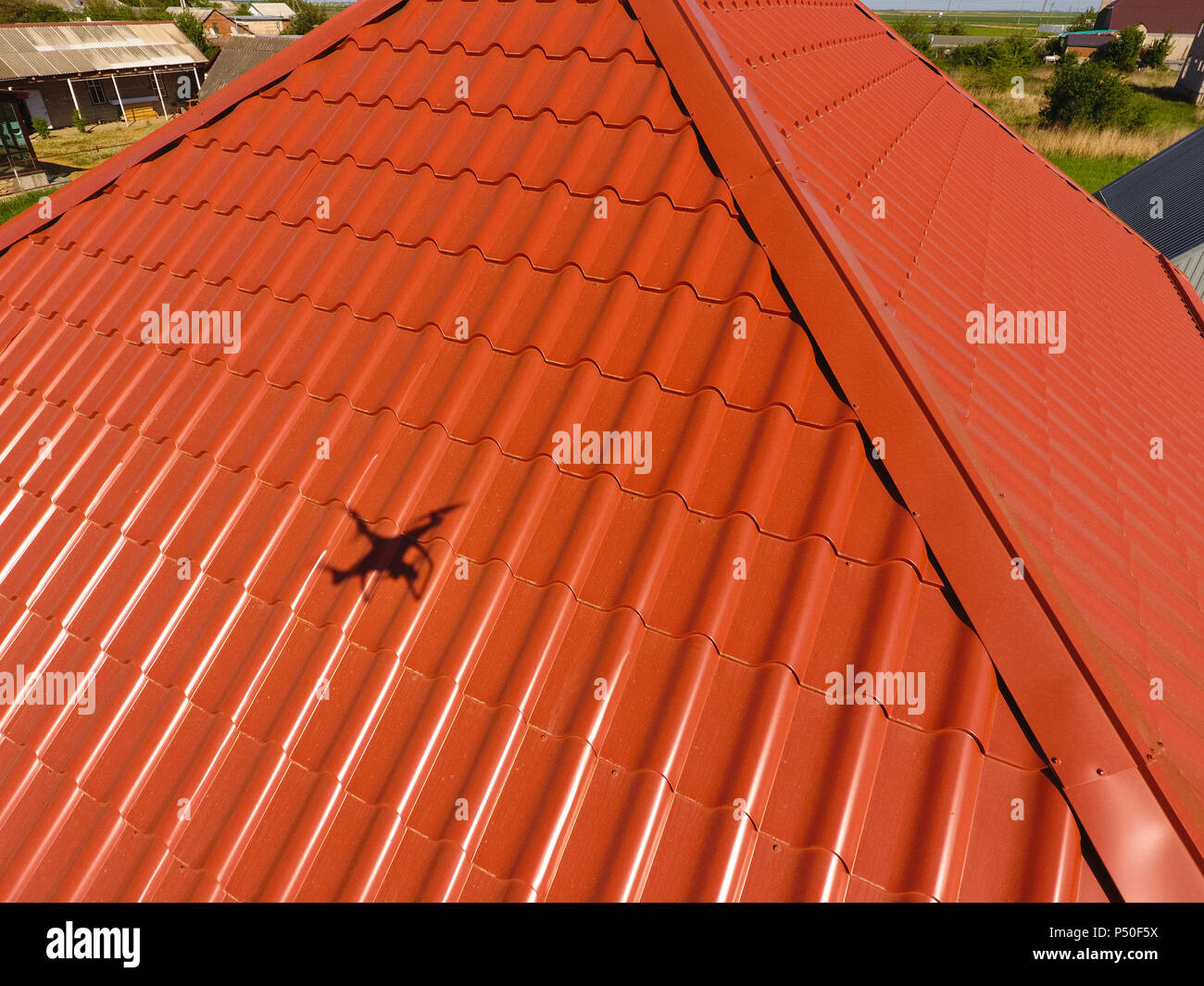House with an orange roof made of metal, top view. Metallic profile ...
