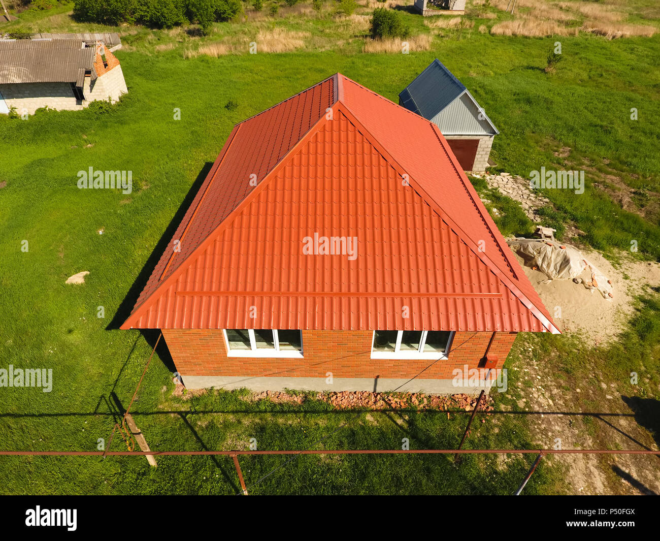 House with an orange roof made of metal, top view. Metallic profile ...