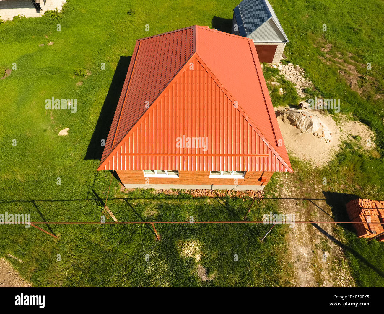House with an orange roof made of metal, top view. Metallic profile ...