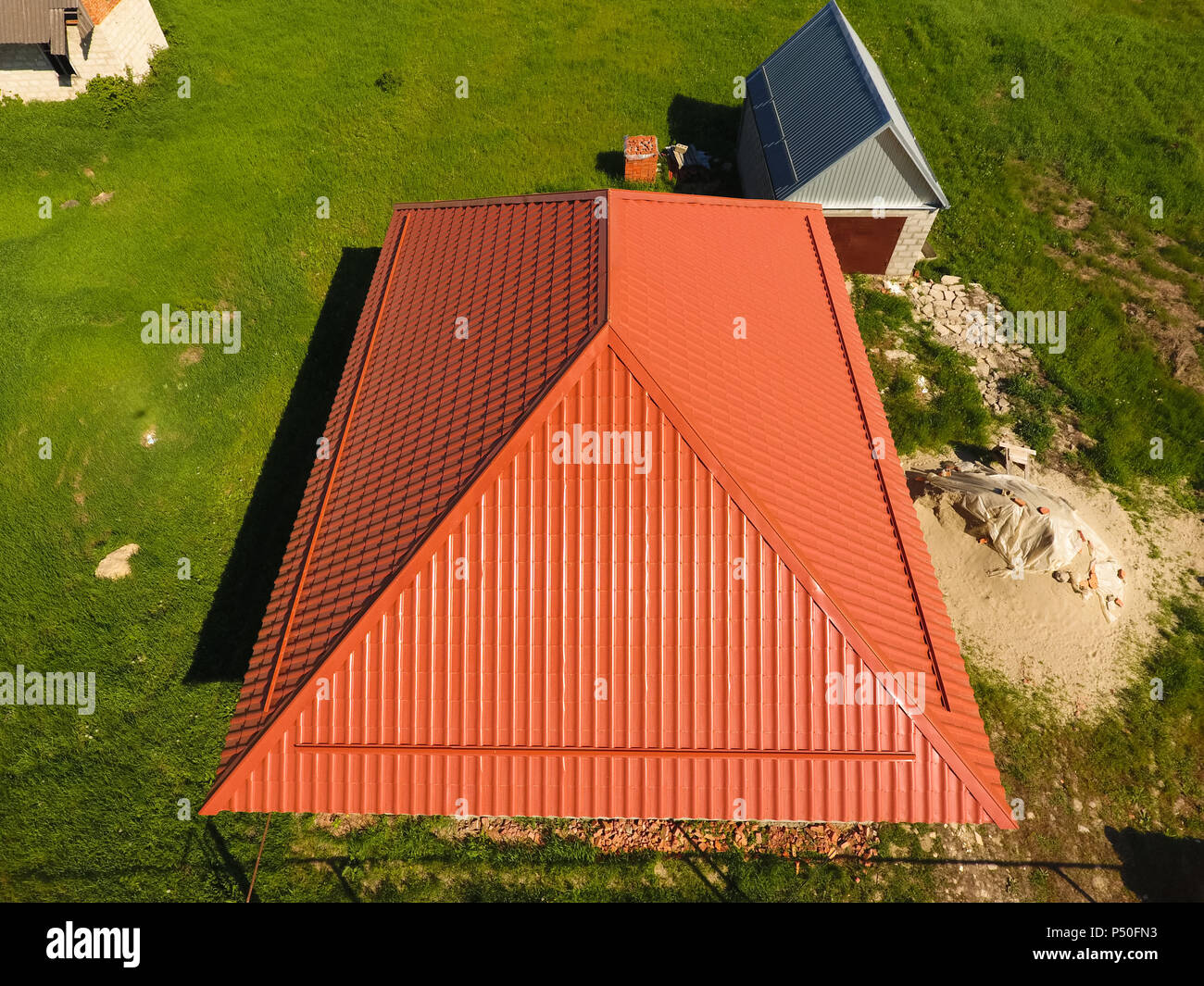 House with an orange roof made of metal, top view. Metallic profile ...