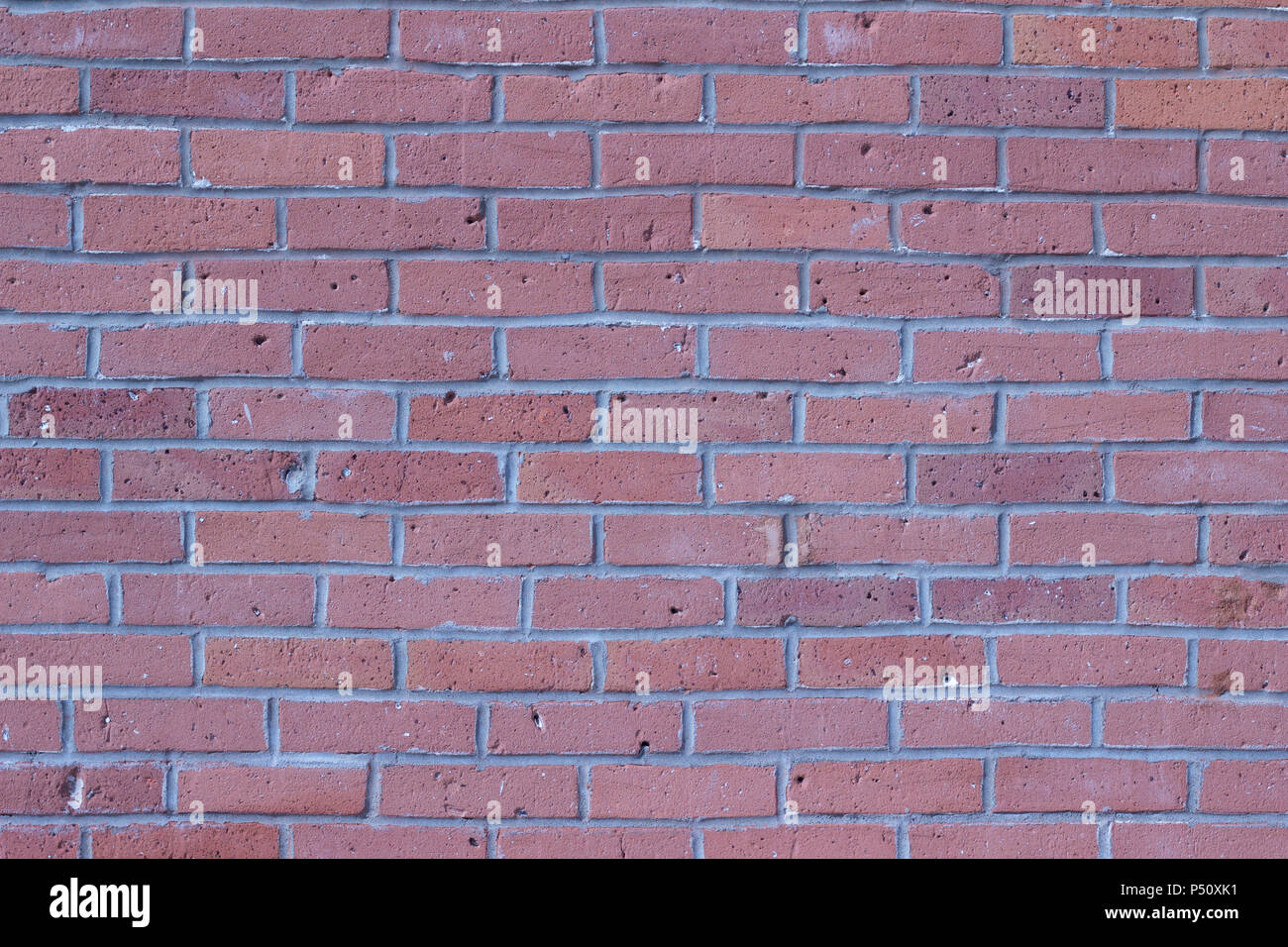Old brick wall background with rosy pink and red bricks of varying ...