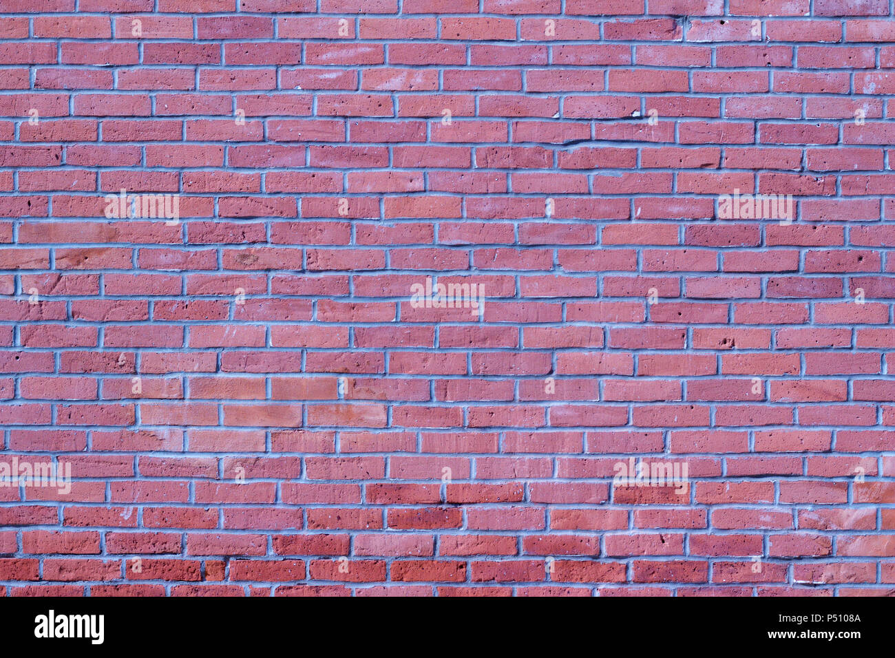 Old brick wall background with rosy pink and red bricks of varying ...