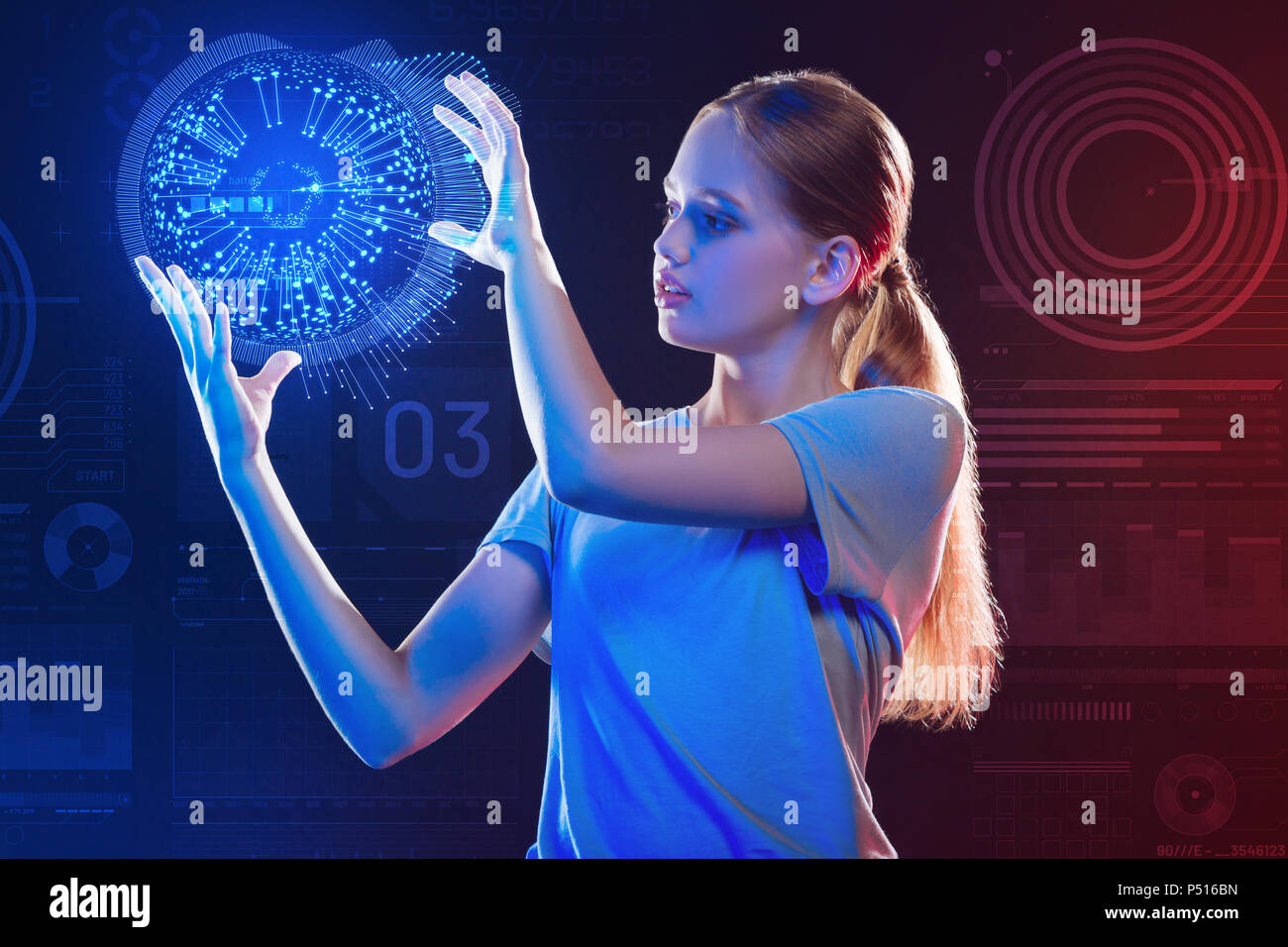 Calm girl looking thoughtfully at the holographic image while holding ...