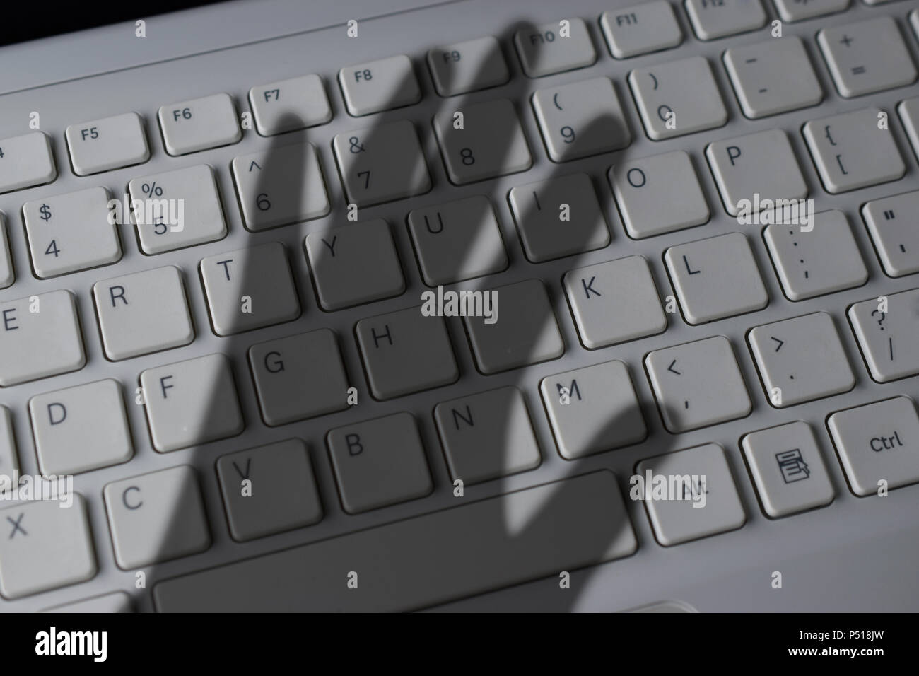computer hacker, Hand shadow on computer keyboard Stock Photo - Alamy