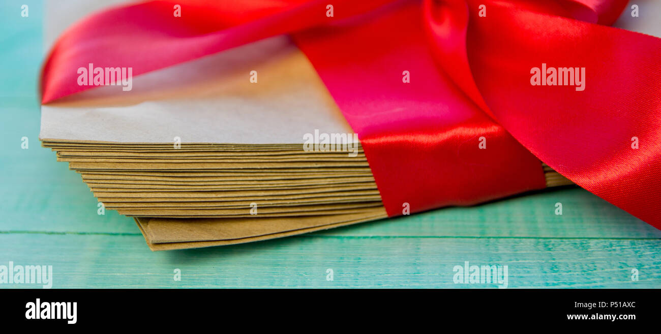 Old letters tied with a red ribbon on old wooden background, top view ...