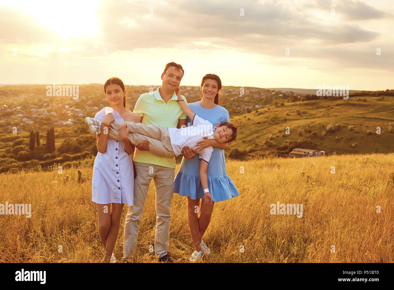 Portrait of a happy family sitting on nature in the grass Stock Photo ...