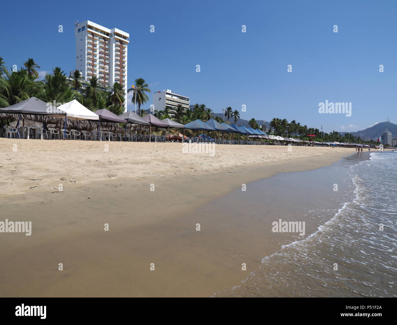 Awesome white hotel and umbrellas on sandy beach at bay of mexican ...