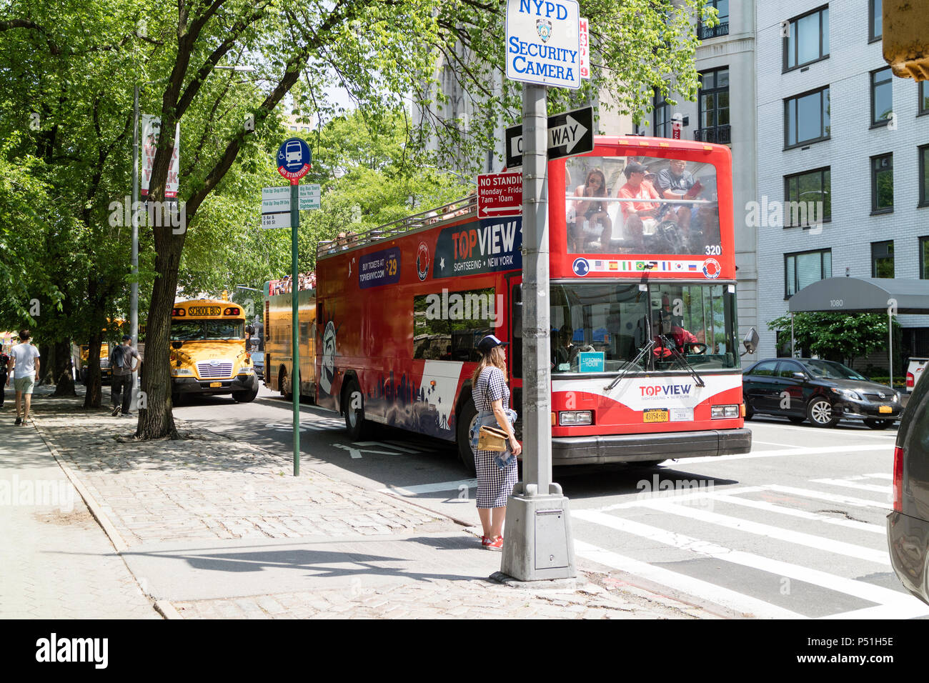 5th Avenue, New York USA. Tour bus and a school bus on this busy ...