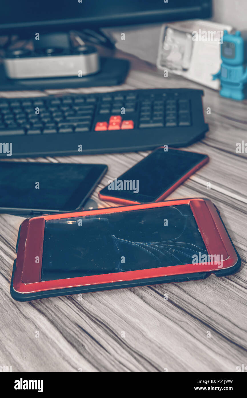 Tablet computer with broken glass, lying on the desktop with the phone ...