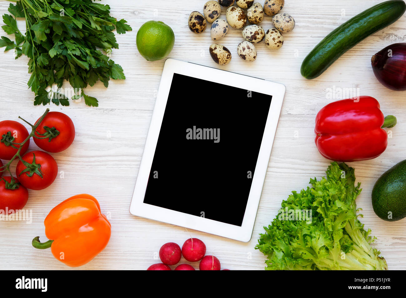Healthy food concept. Raw fruits and vegetables wirh tablet on a white ...