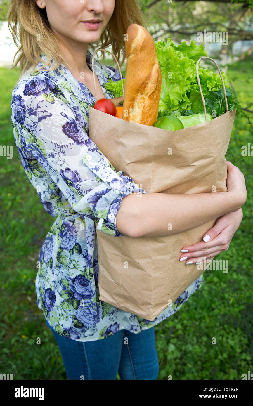 Beautiful young woman carrying paper bag of groceries Stock Photo - Alamy