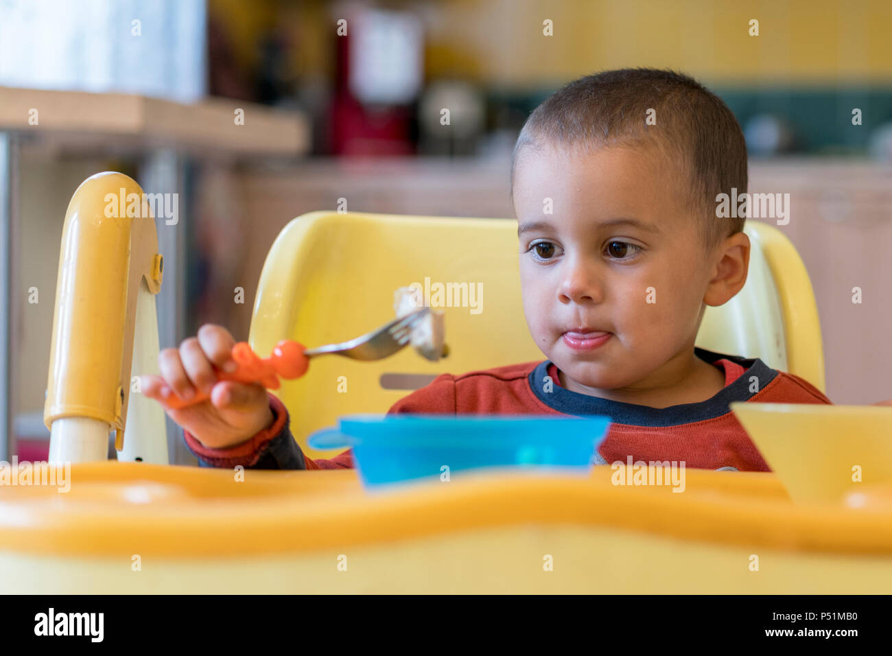 The boy 2 years eating meat. Children's table. The concept of the child ...