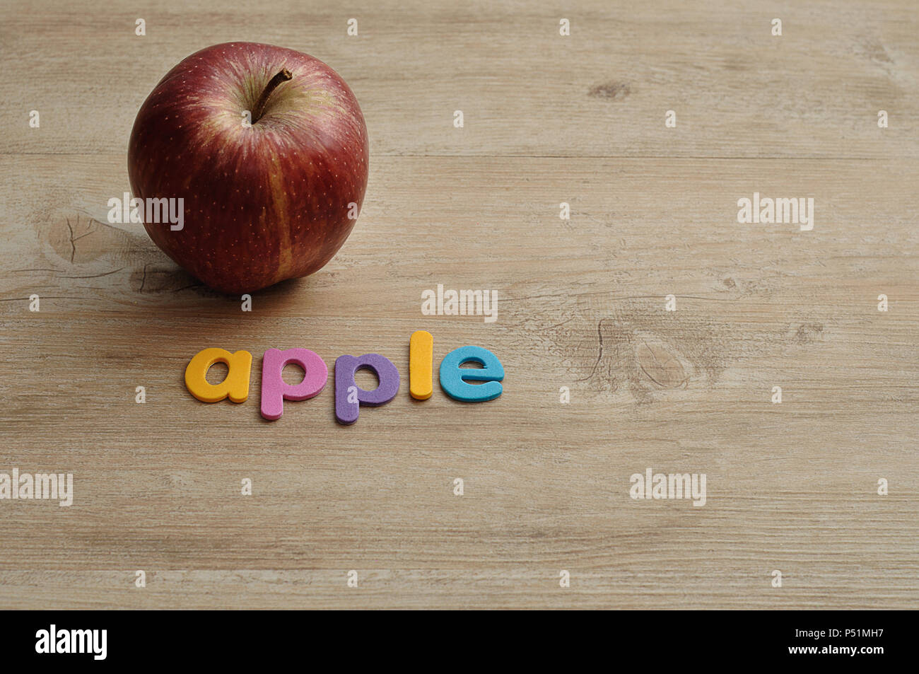 An apple with the word apple on a wooden background Stock Photo - Alamy