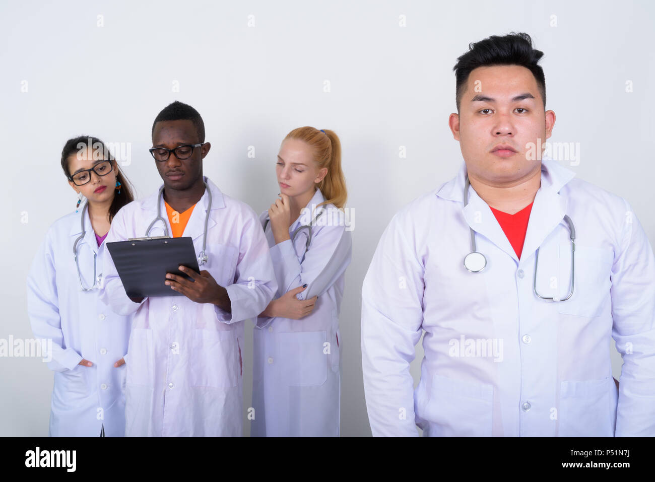 Studio shot of young Asian man doctor with diverse group of mult Stock ...