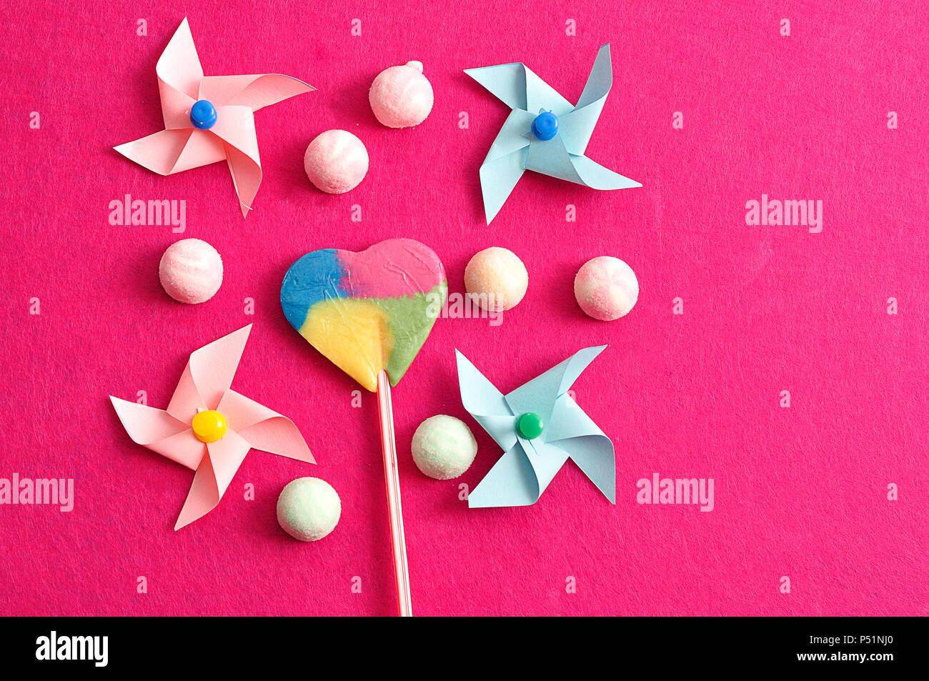 A colorful heart shape lollipop displayed with colorful pinwheels and ...