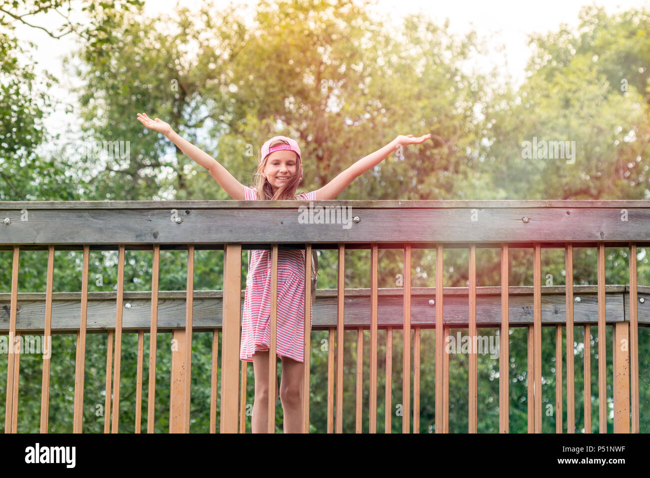 Lovely little girl standing on a bridge Stock Photo - Alamy