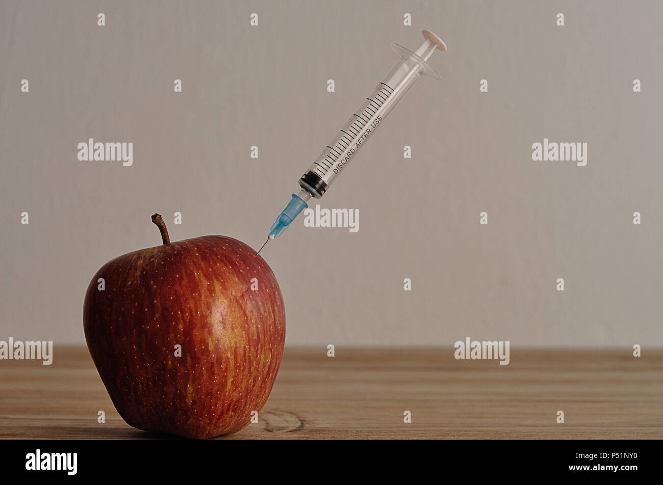 An injection needle stuck into an apple Stock Photo - Alamy