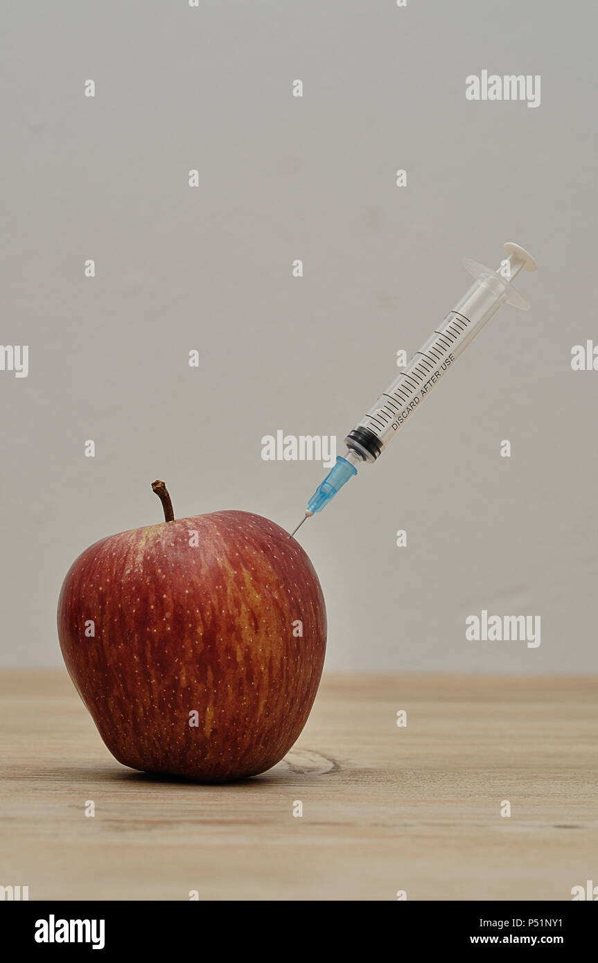 An injection needle stuck into an apple Stock Photo - Alamy