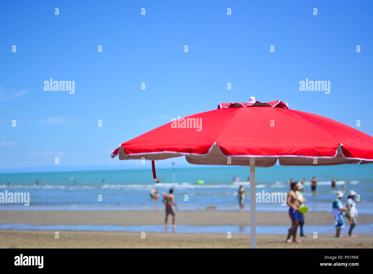 A red beach umbrella open on the beach Stock Photo - Alamy