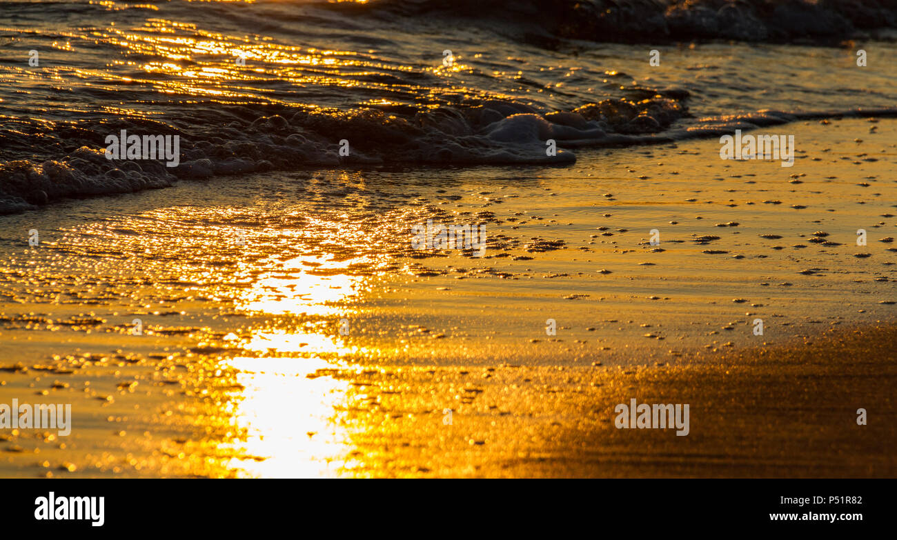 Beautiful colorful shapes created by breaking waves on a sandy shore ...