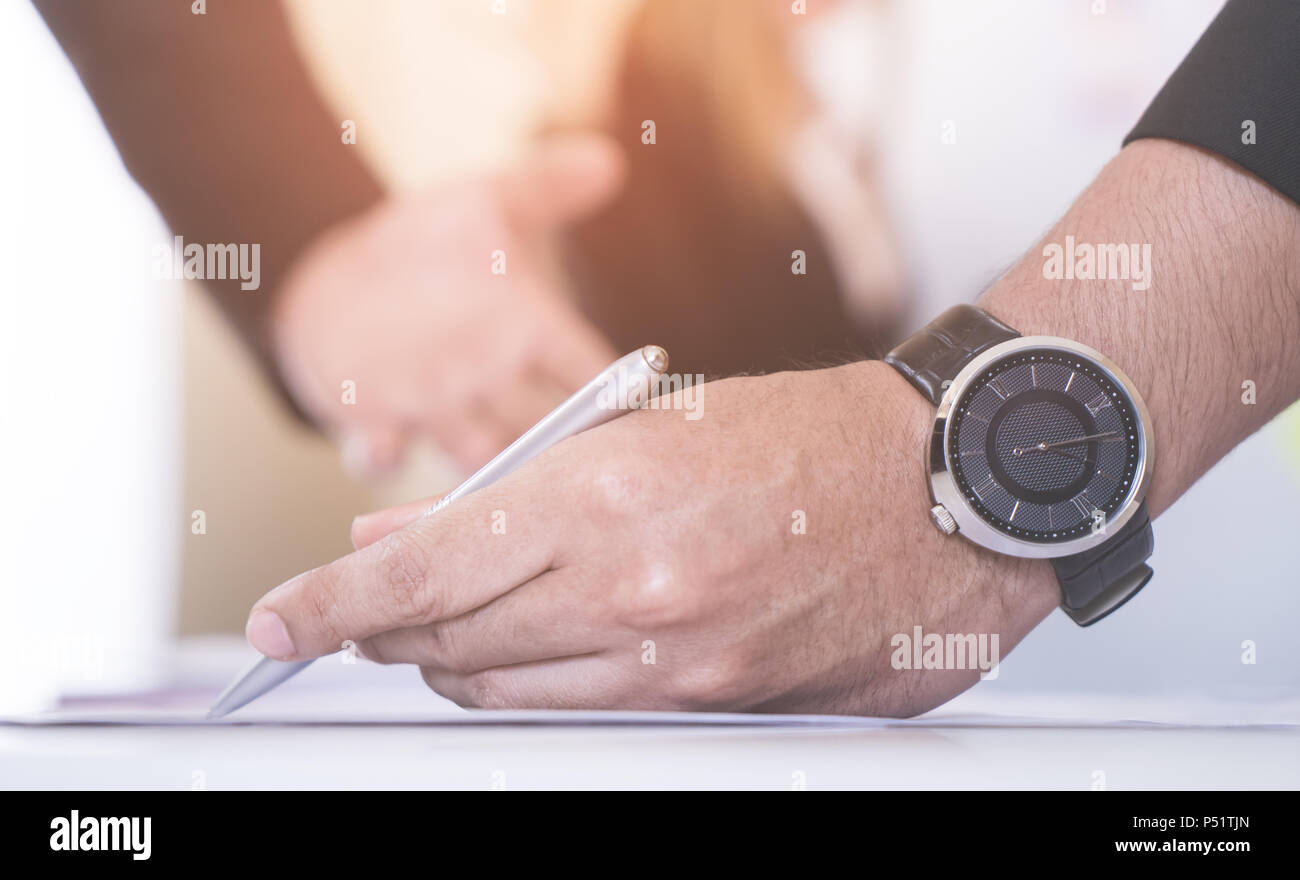 Business man marking on data sheet using metal pen Stock Photo - Alamy