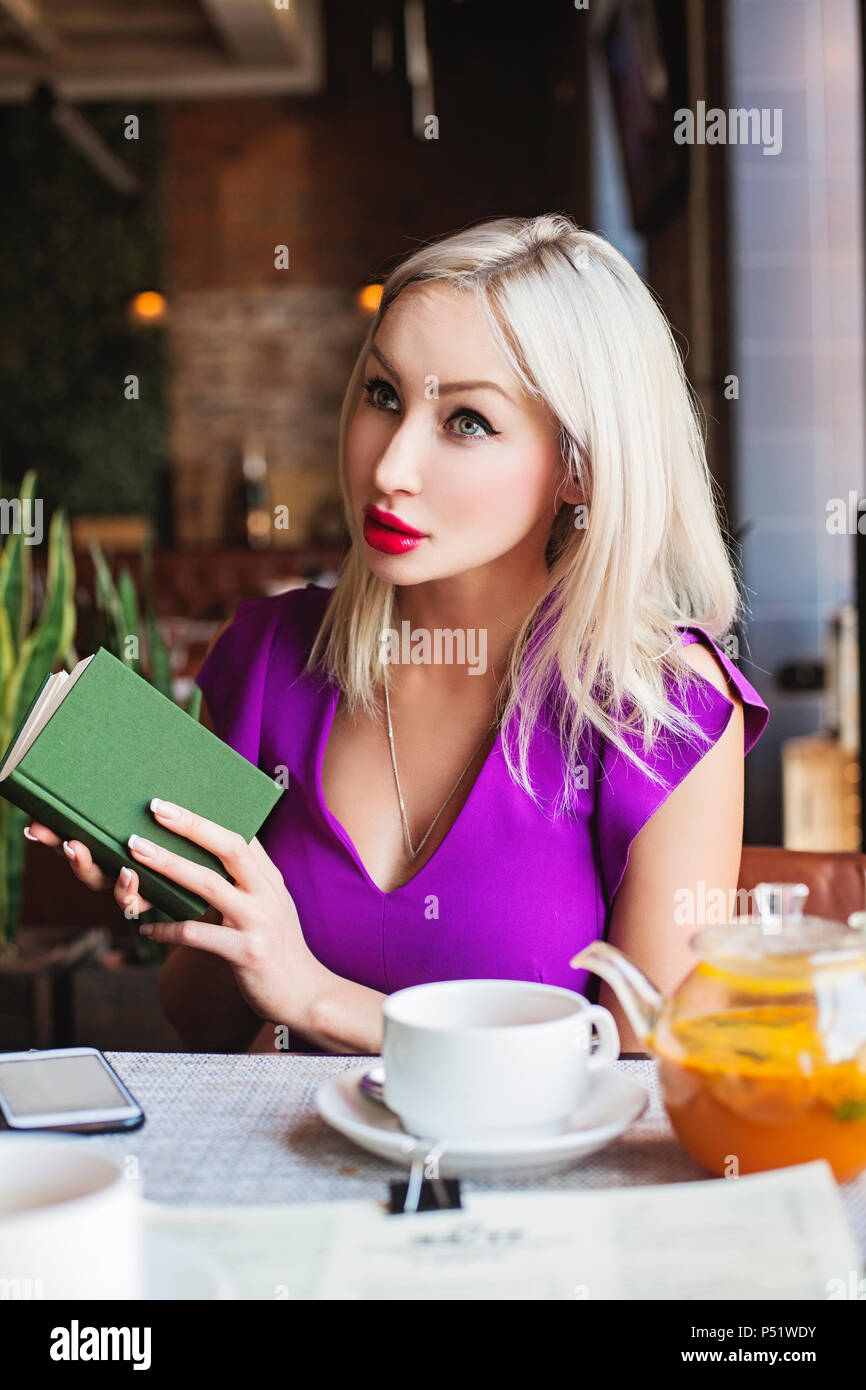 Pretty Woman with Book in Restaurant Stock Photo - Alamy