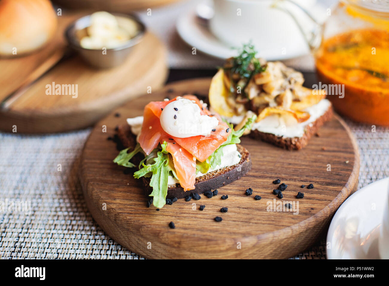 Danish smorrebrod sandwich with salmon fish and egg on wooden board ...