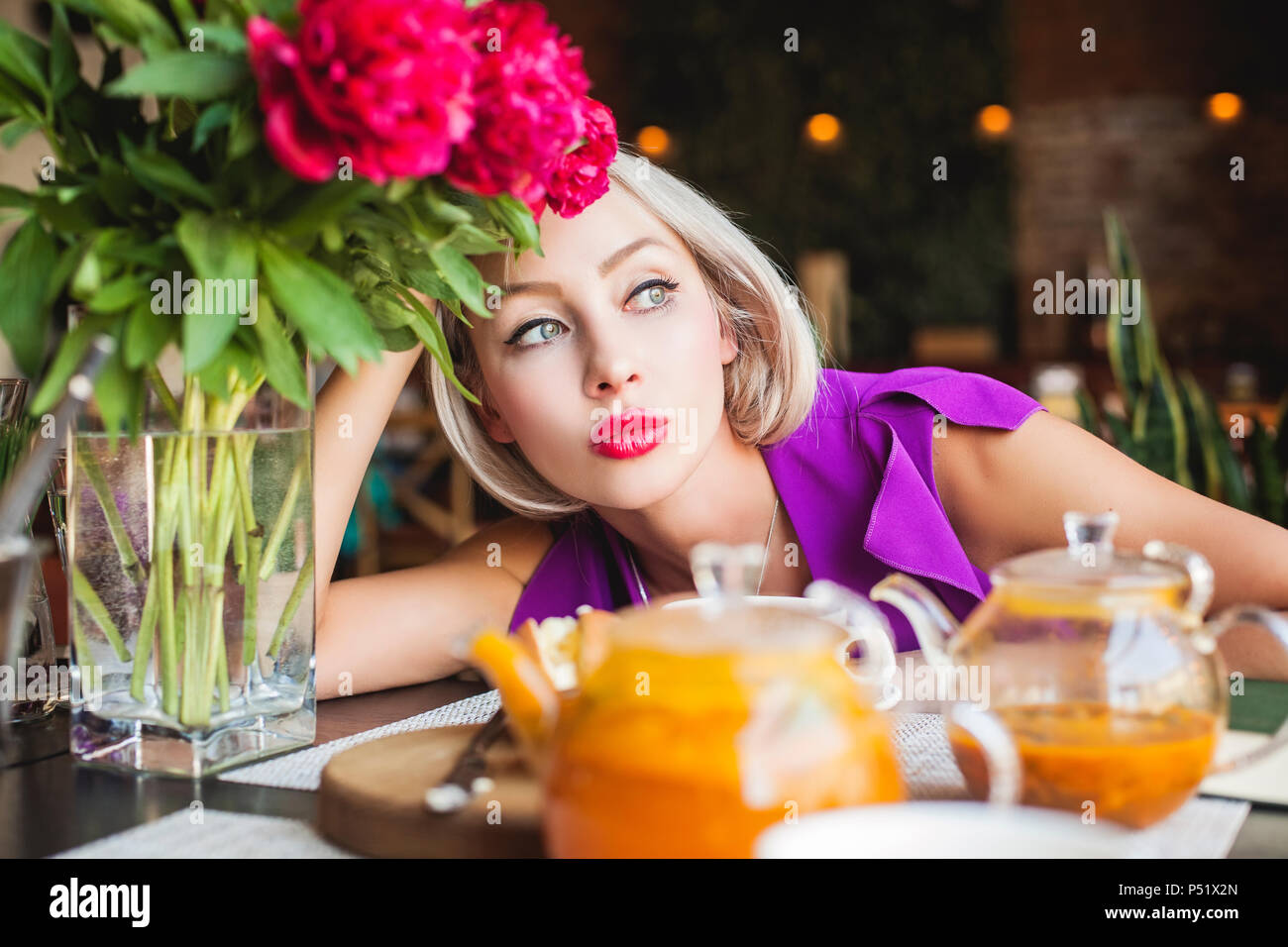 Blonde woman sitting in restaurant Stock Photo - Alamy