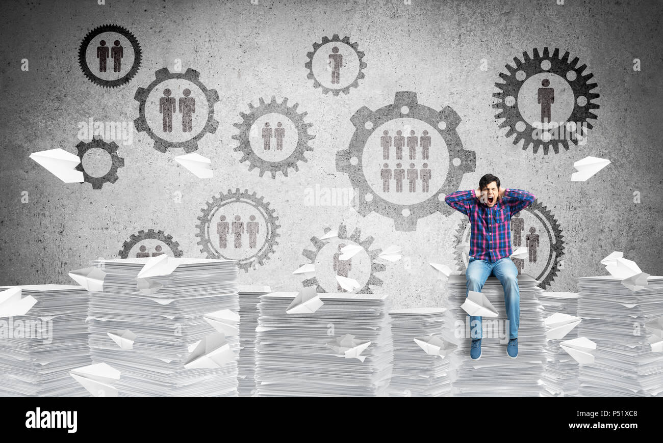 Attractive man sitting on pile of paper documents Stock Photo - Alamy