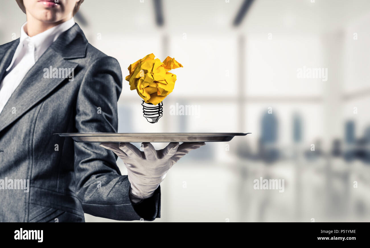 Hand of waiter presenting crampled paper lightbulb Stock Photo - Alamy