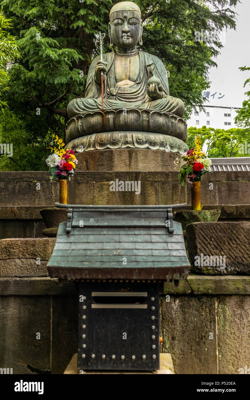 Stone Buddha statue in a Shintoist shrine in Tokyo - 2 Stock Photo - Alamy