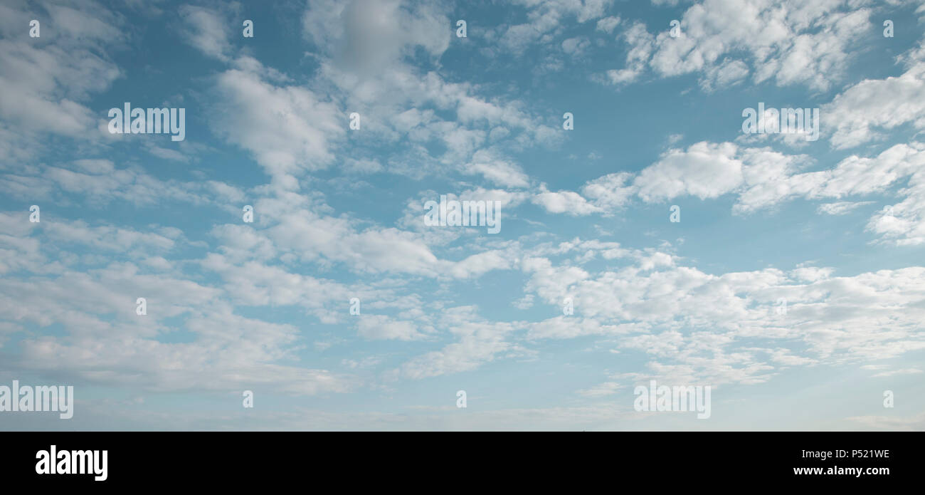 Blue sky with white fluffy clouds - midday cloudscape Stock Photo - Alamy