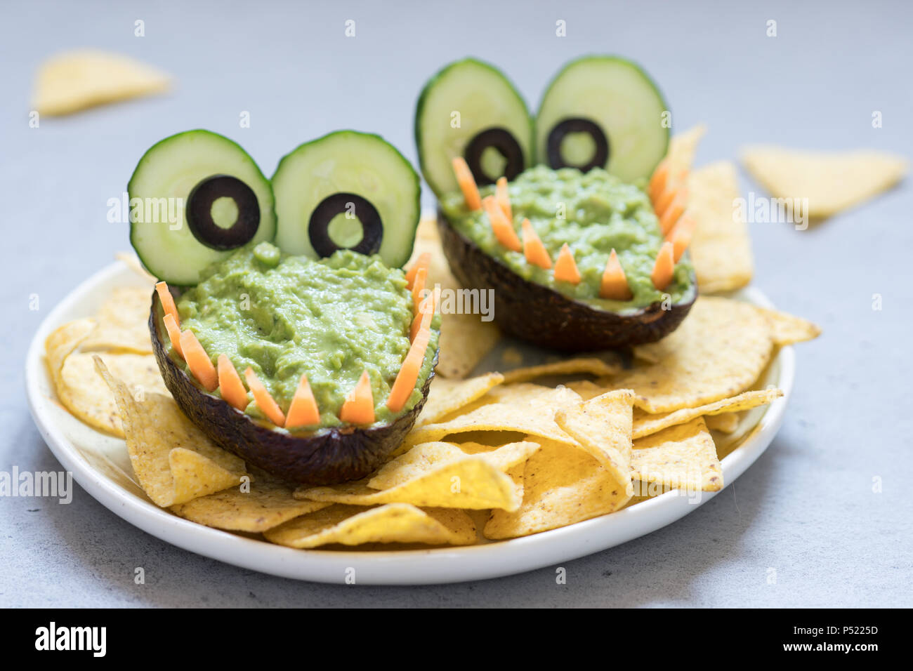 Funny alligator avocado bowl guacamole dip and nachos Stock Photo - Alamy