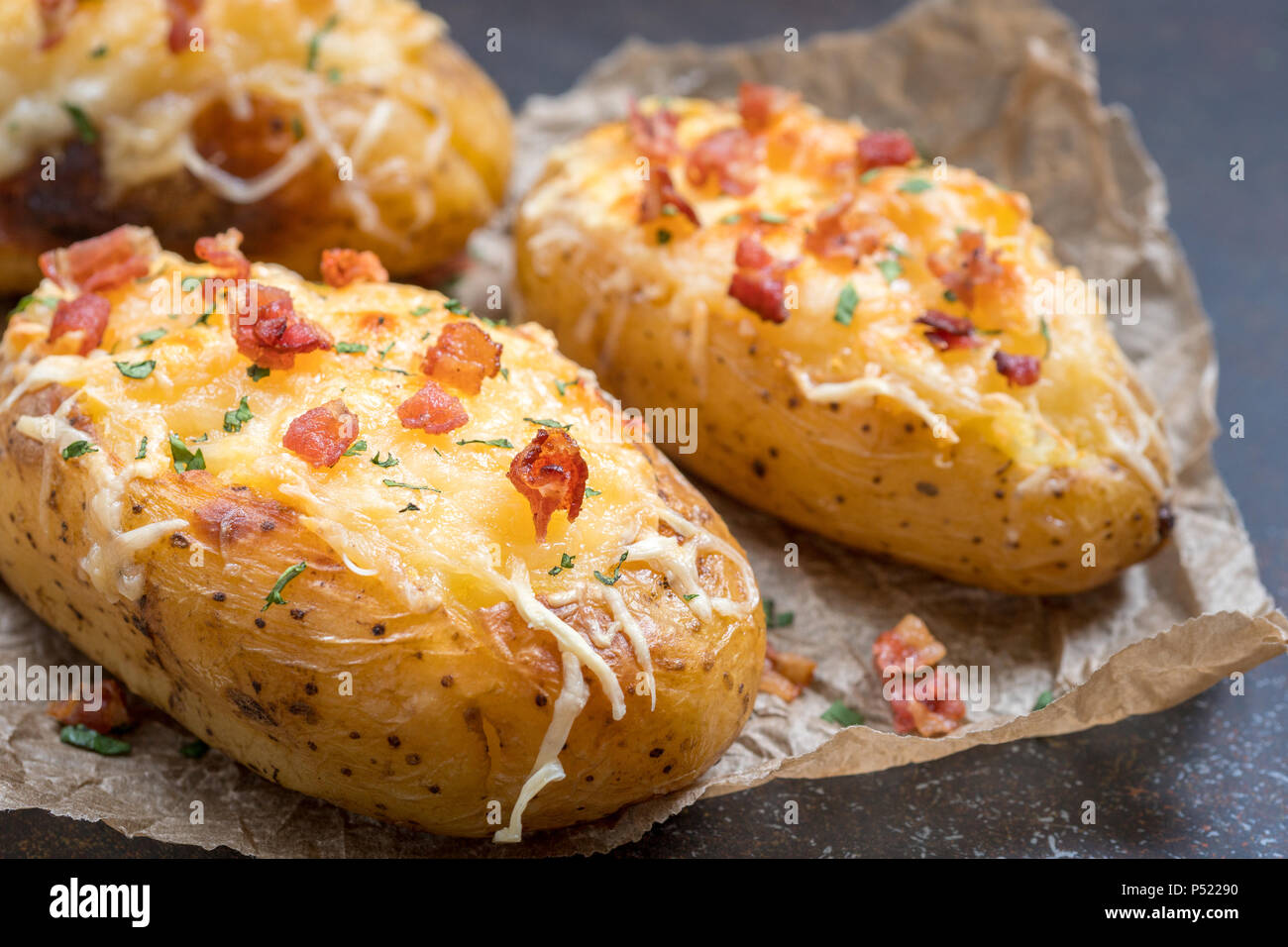 Baked loaded potato with bacon, cheese and onion Stock Photo - Alamy
