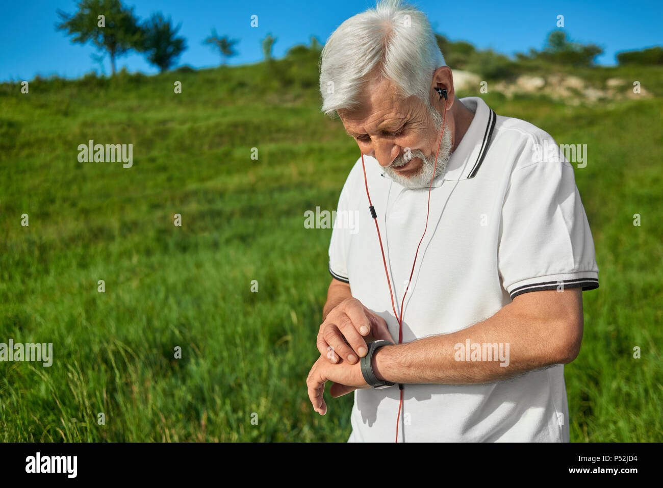 Old man checking time during outdoors sport activities. Having accurete ...