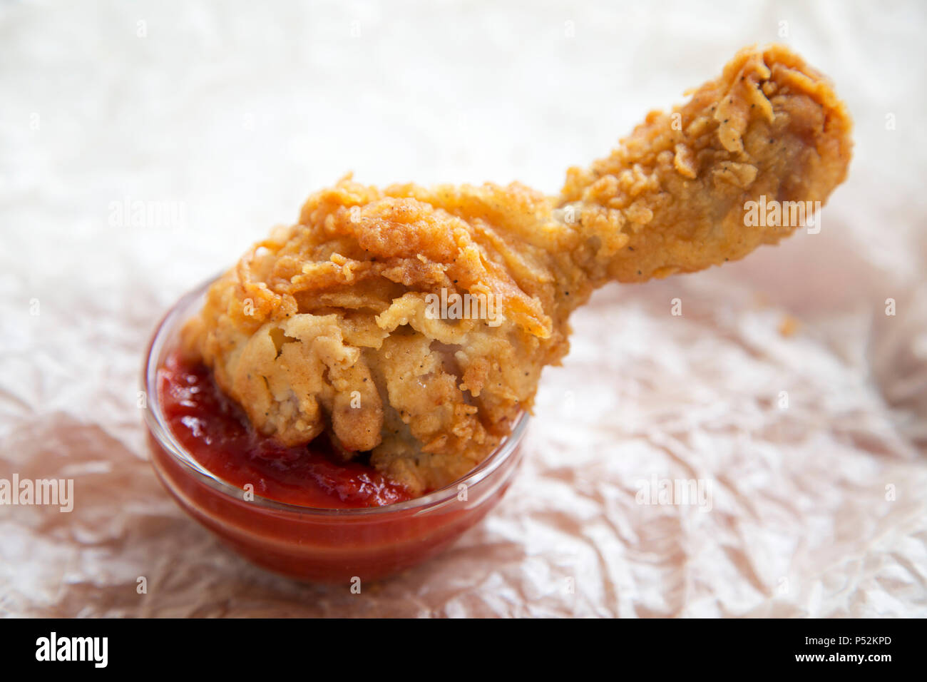Fried chicken leg in a bowl of sauce, side view. Close-up Stock Photo ...