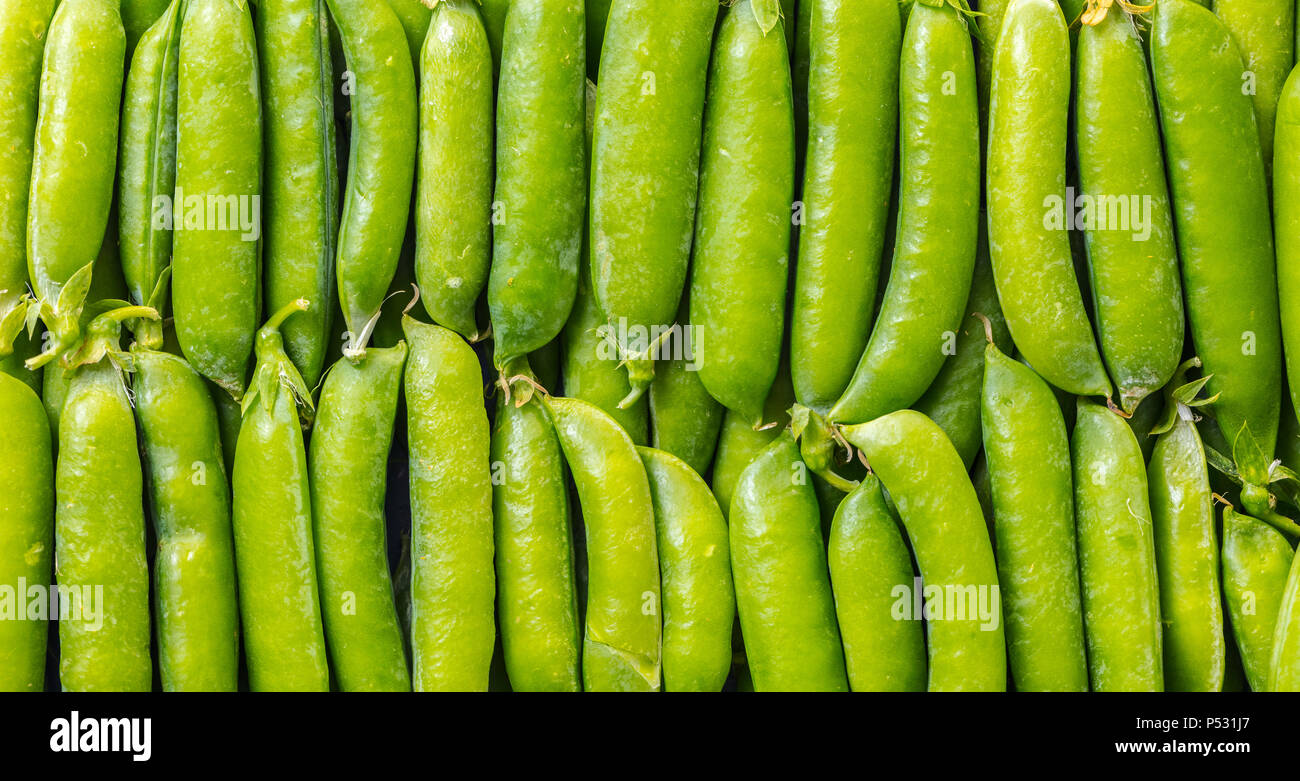 food background of a texture of green peas pods Stock Photo - Alamy