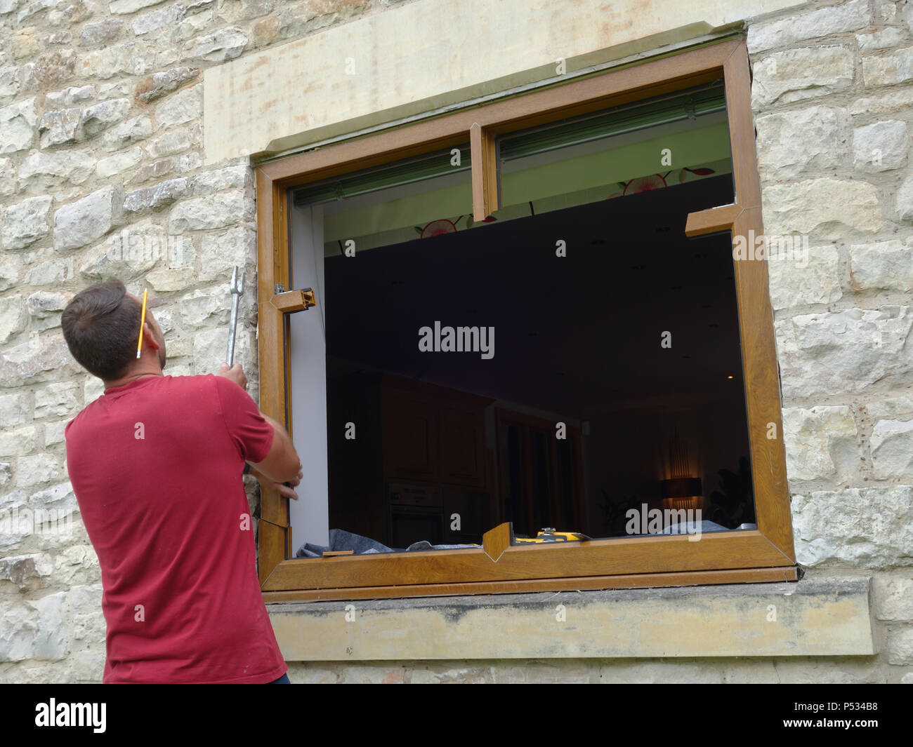 Window fitter replacing old double glazed uPVC window frames with new ...