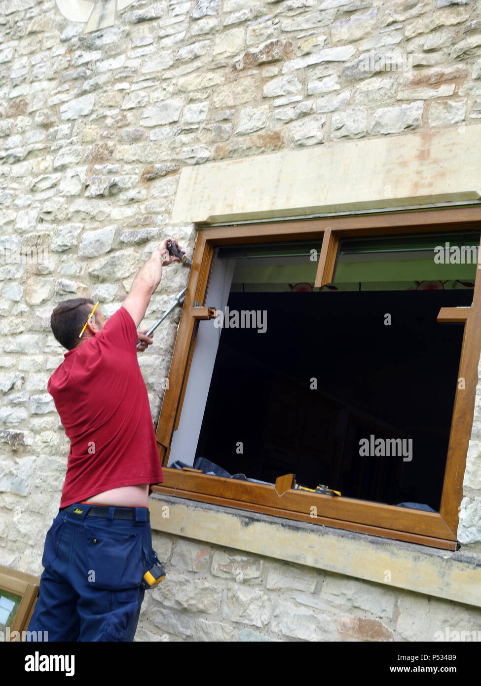 Window fitter replacing old double glazed uPVC window frames with new ...