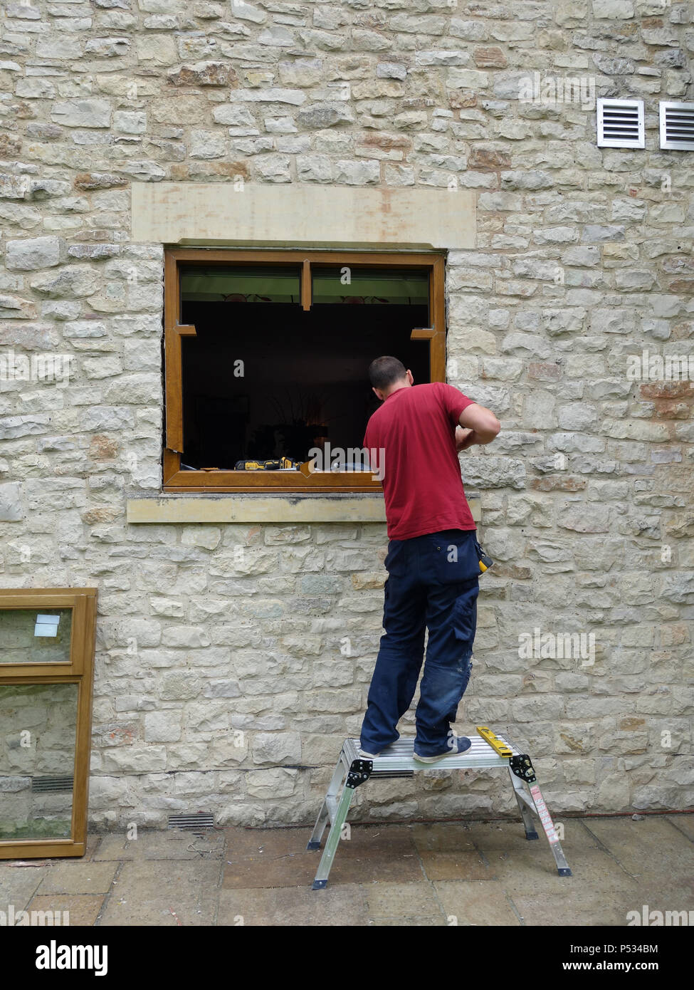 Window fitter replacing old double glazed uPVC window frames with new ...