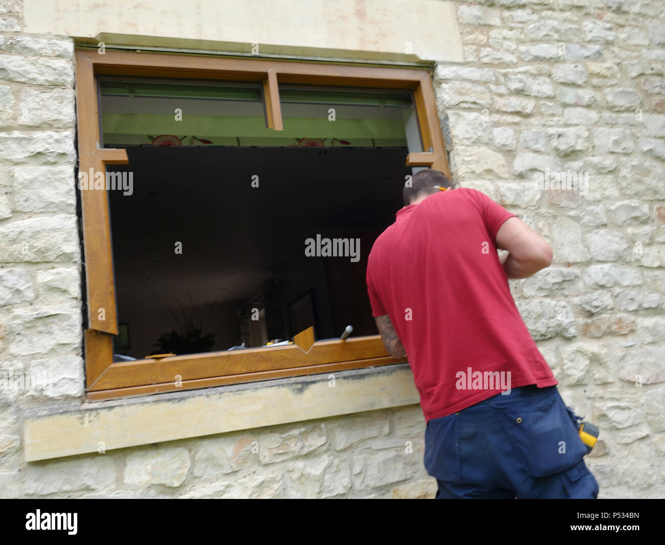 Window fitter replacing old double glazed uPVC window frames with new ...