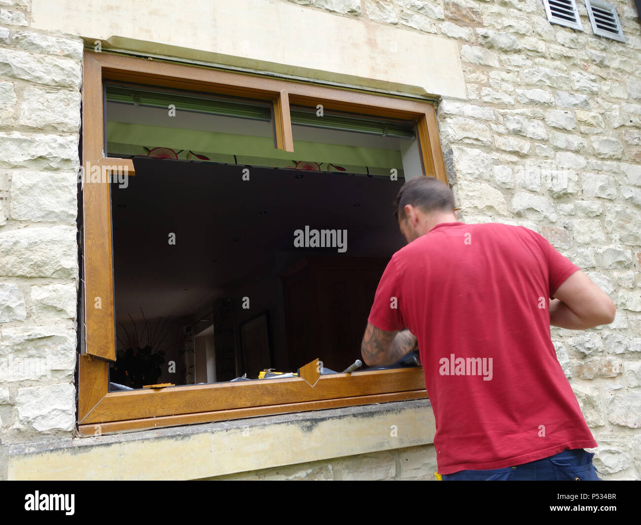 Window fitter replacing old double glazed uPVC window frames with new ...