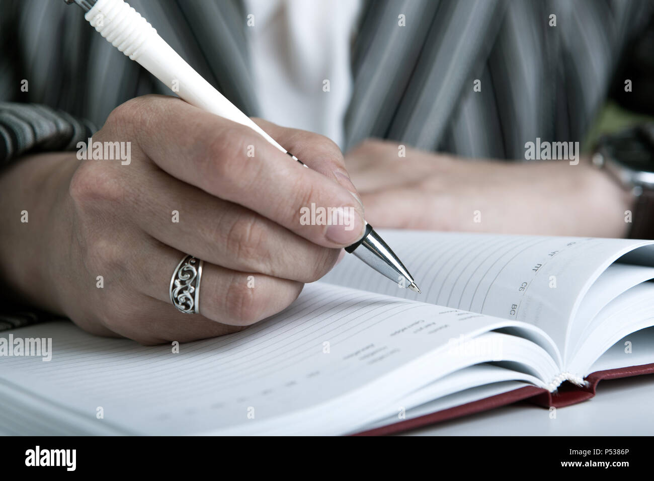diary and human hand holding a pen close-up Stock Photo - Alamy