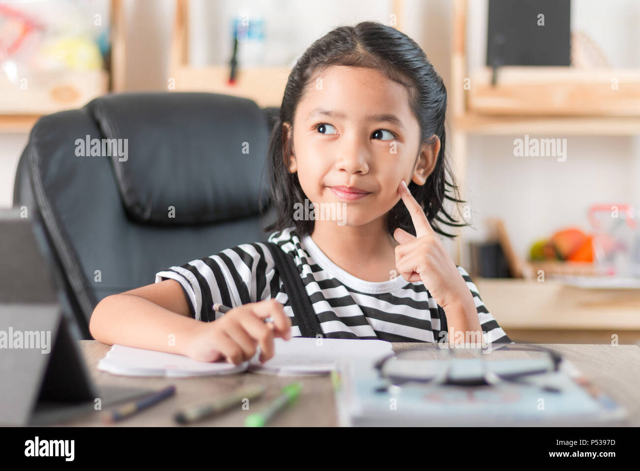 Asian little girl doing homework on wooden table select focus shallow ...