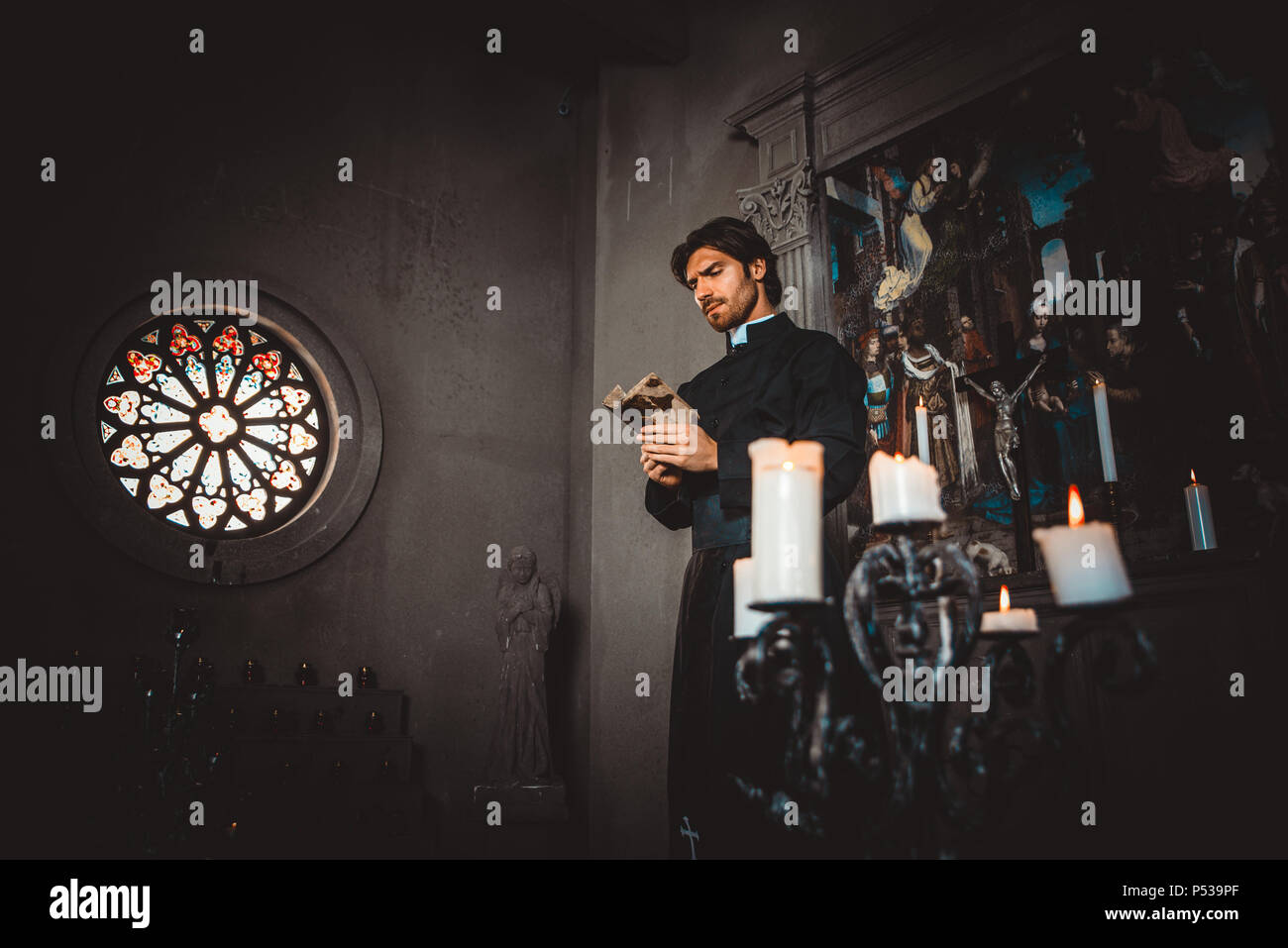 Priest reading and praying in the church Stock Photo - Alamy