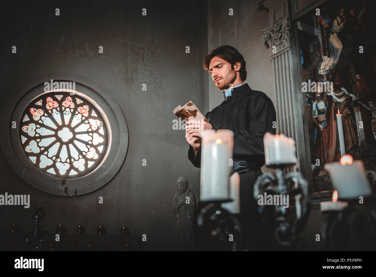 Priest reading and praying in the church Stock Photo - Alamy