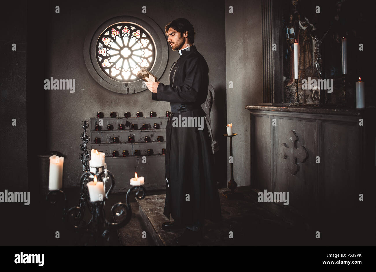 Priest reading and praying in the church Stock Photo - Alamy