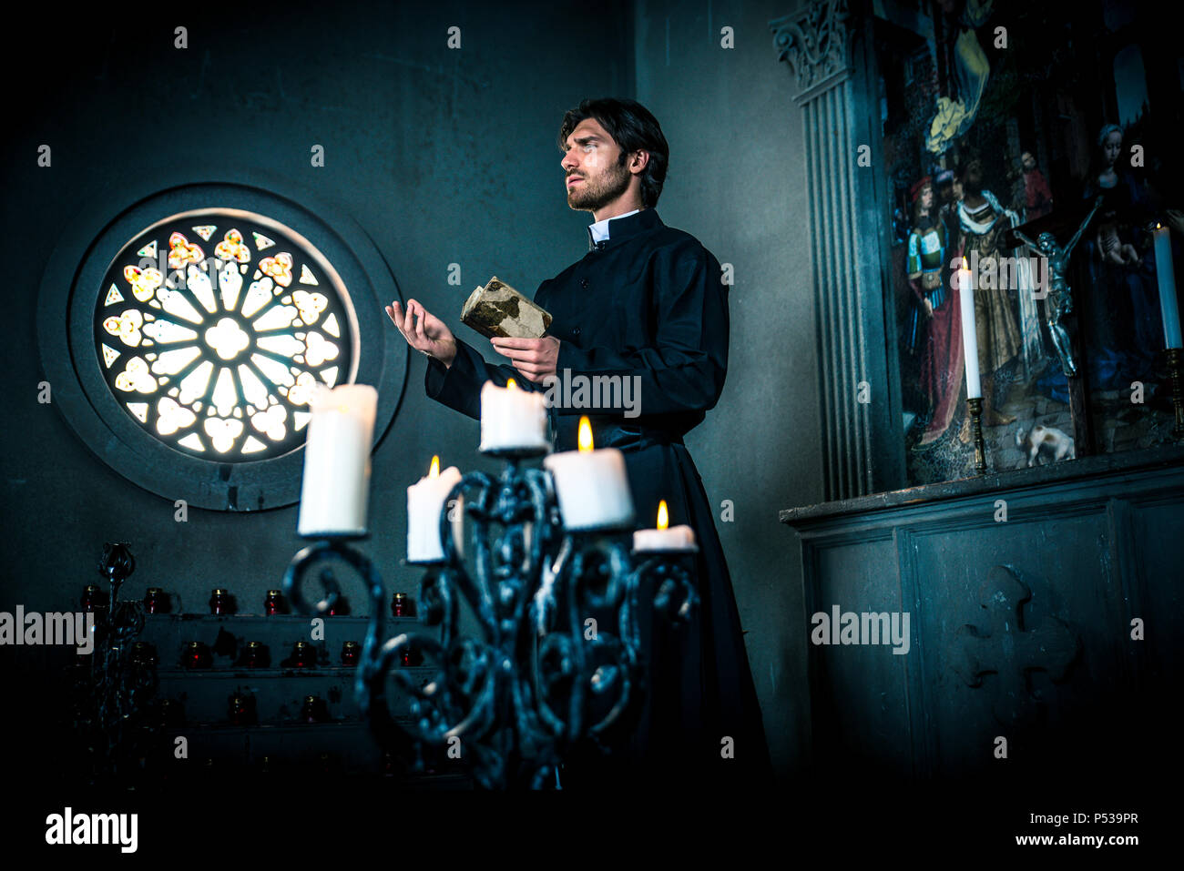 Priest reading and praying in the church Stock Photo - Alamy