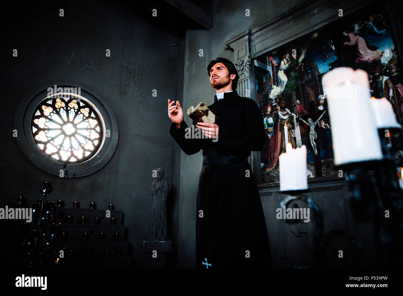 Priest reading and praying in the church Stock Photo - Alamy