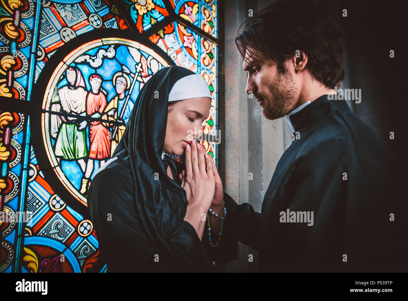 Nun and priest praying and spending time in the monastery Stock Photo ...